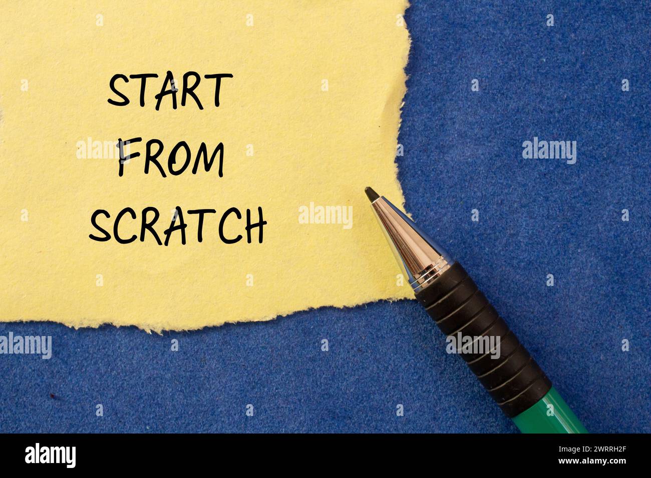 Start from scratch words written on yellow torn paper with blue ...