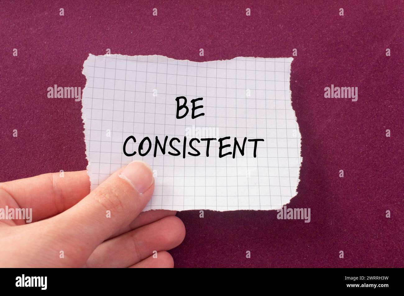 Be consistent words written on torn paper with purple background ...