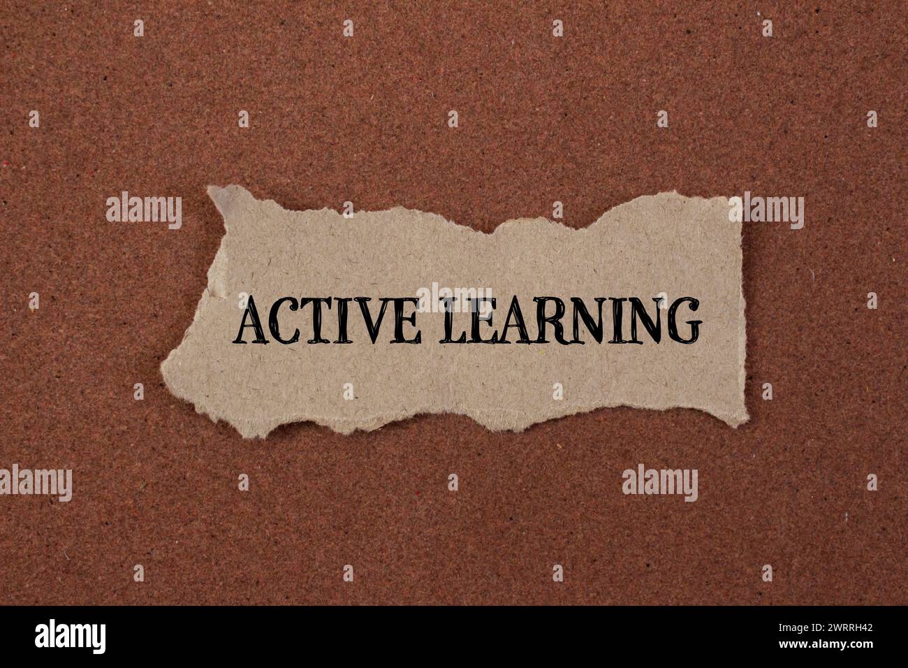 Active learning words written on torn paper with brown background ...