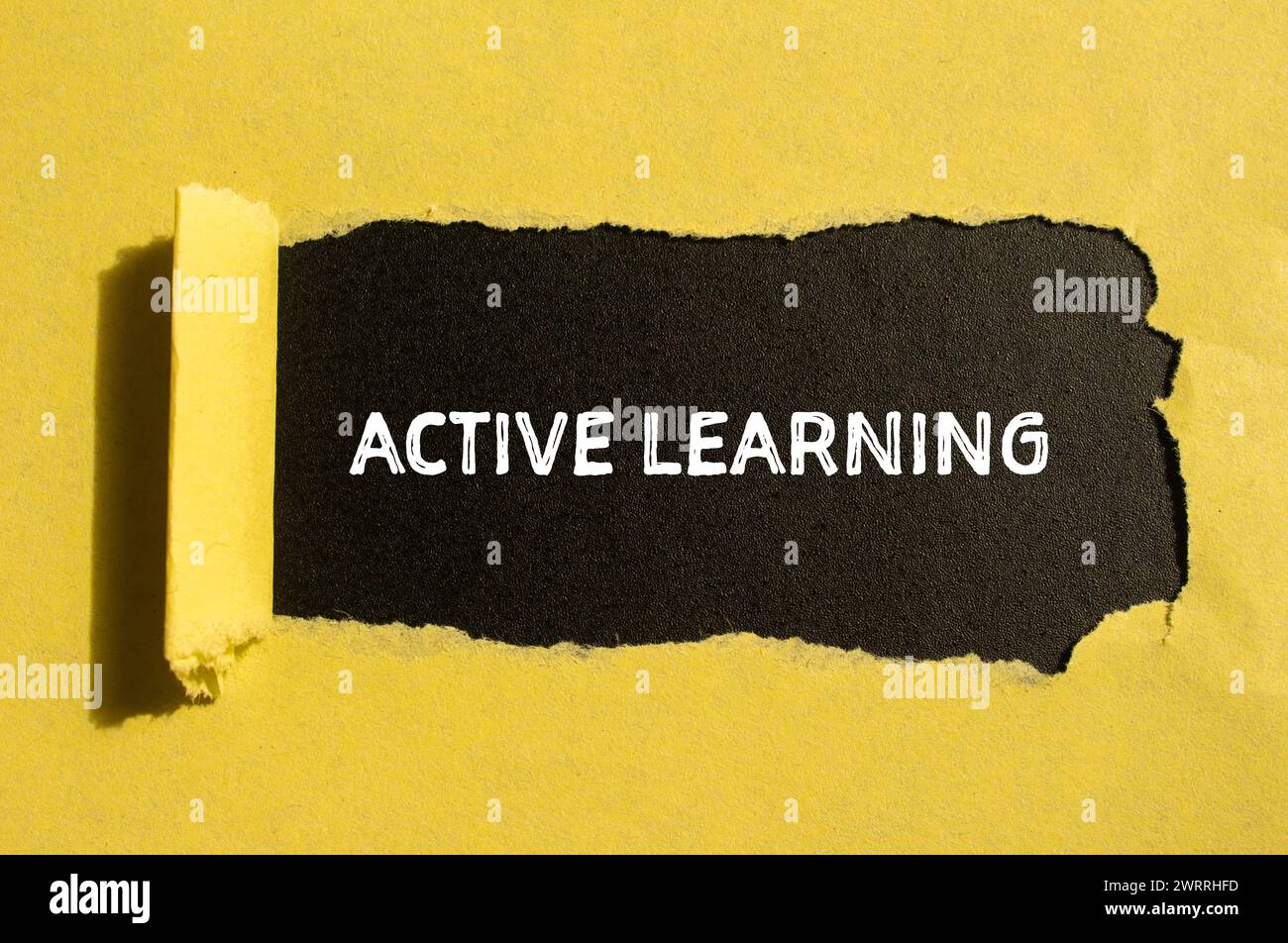 Active learning words written on yellow torn paper with black ...