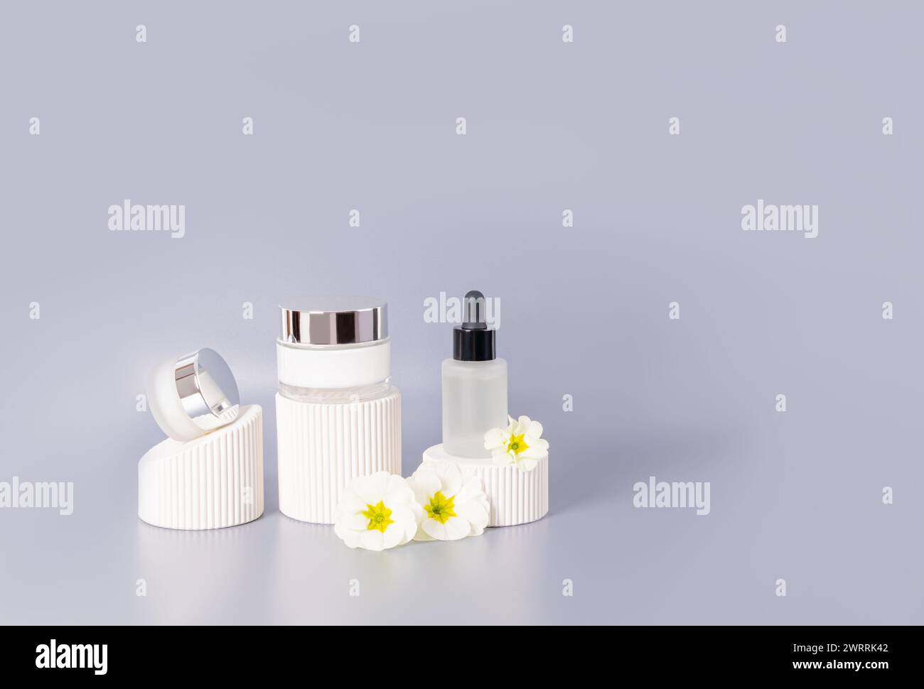 Set of cosmetic natural self-care products on white embossed podiums on ...