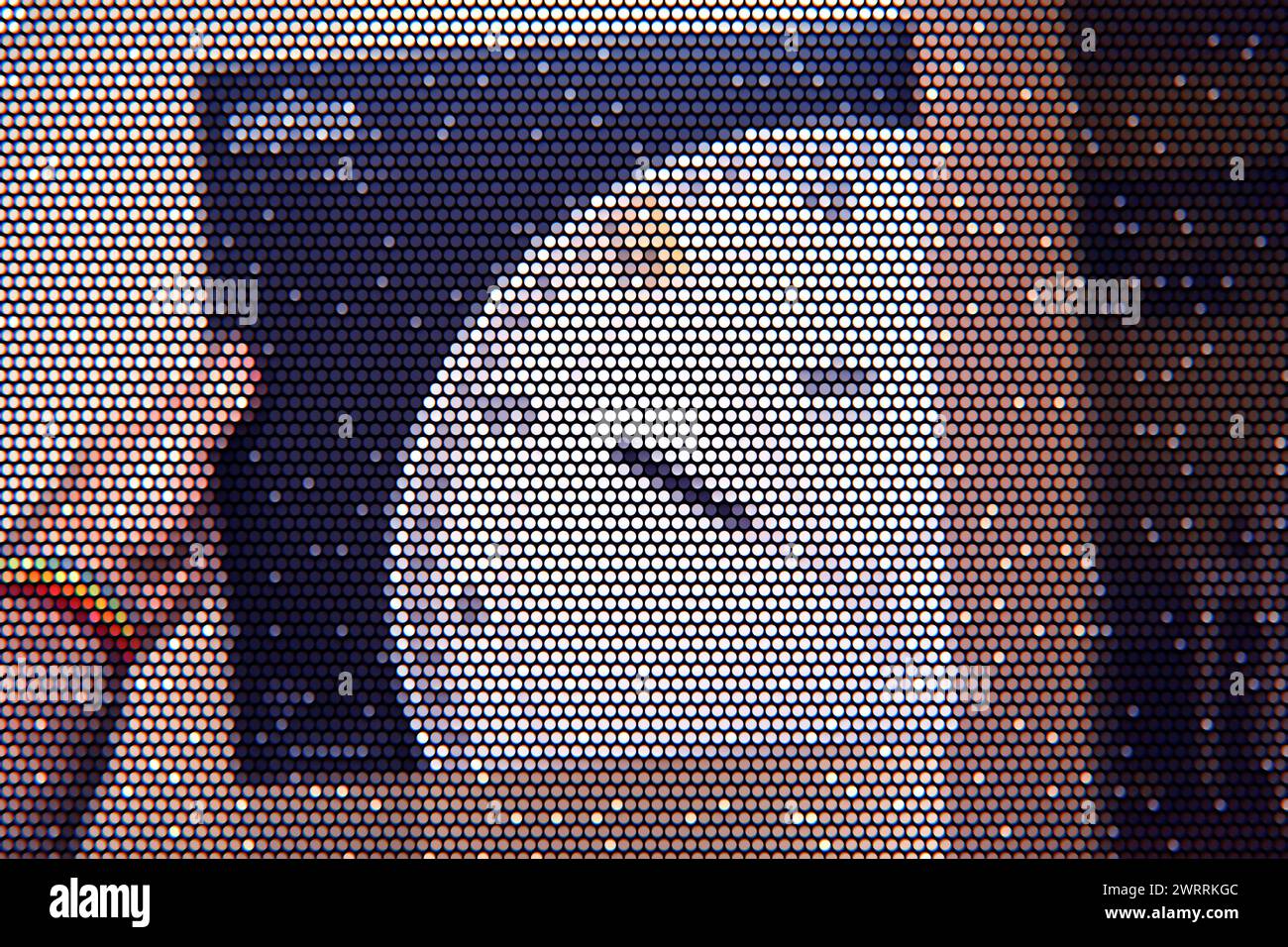 A person standing with a cell phone raised in front of a digital clock ...