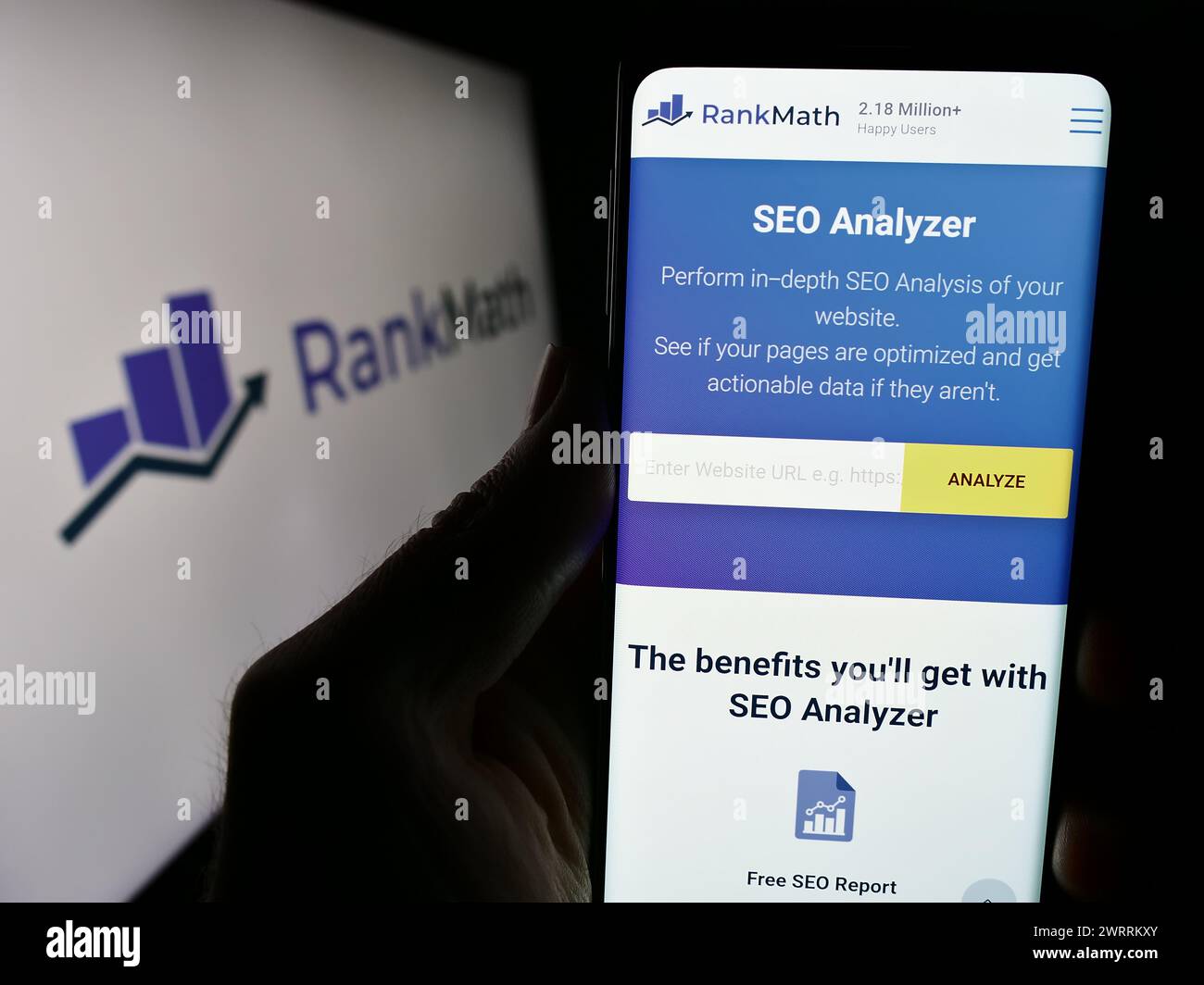 Person holding cellphone with webpage of Indian WordPress SEO company Rank Math in front of ...