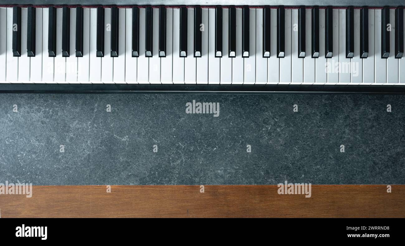 Piano keyboard on a dark marble and wood surface, top view Stock Photo ...