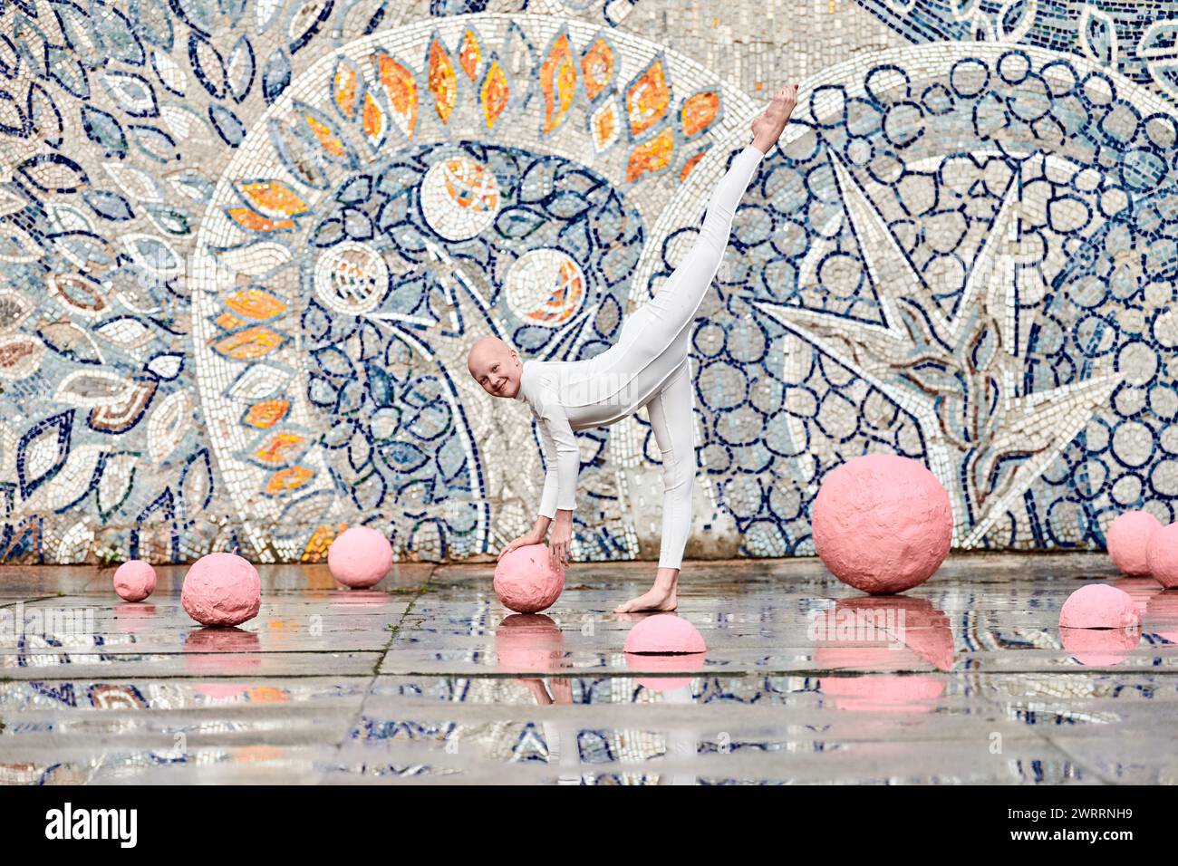 Outdoor dance of young ballerina girl with alopecia in white futuristic ...