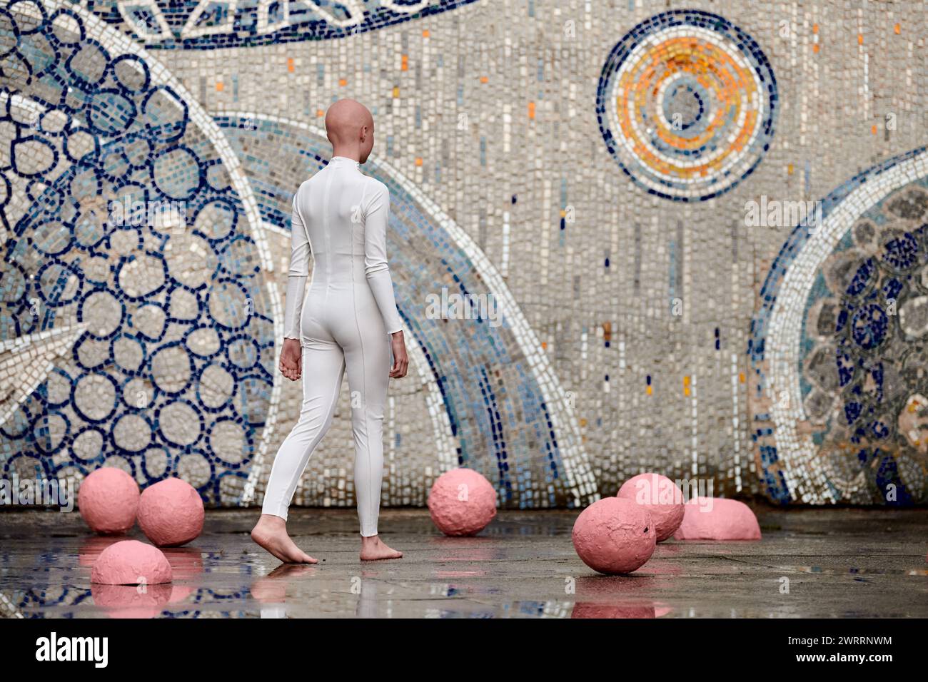 Young hairless girl ballerina with alopecia in white futuristic suit ...