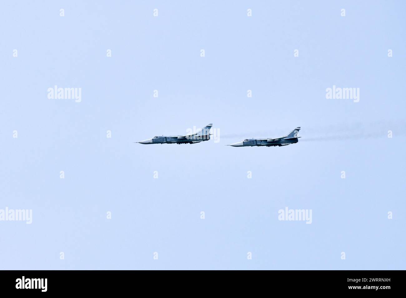 Two Russian military fighter planes armed with missiles flies in blue ...