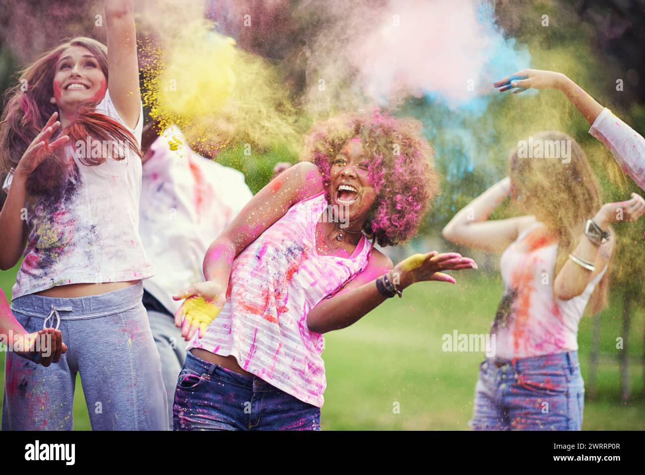 Friends, happiness and powder paint at color festival in park, fun with ...