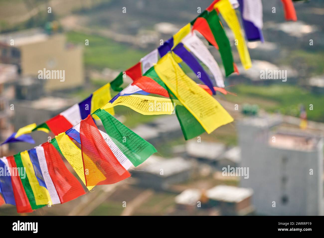 Colorful Tibetan prayer flags on blurred Kathmandu cityscape background ...
