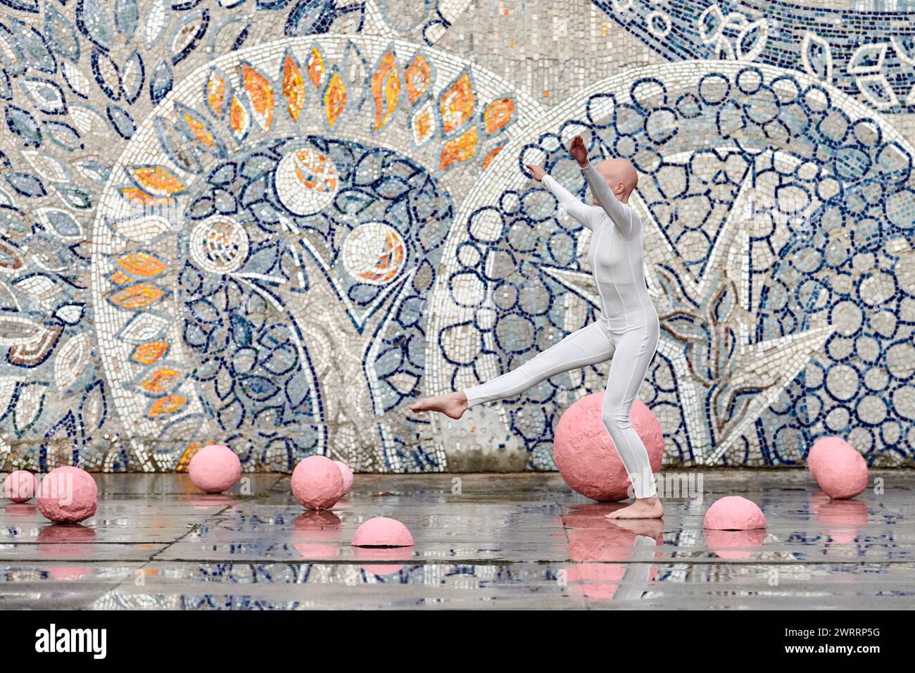 Young hairless girl ballerina with alopecia in white futuristic suit ...