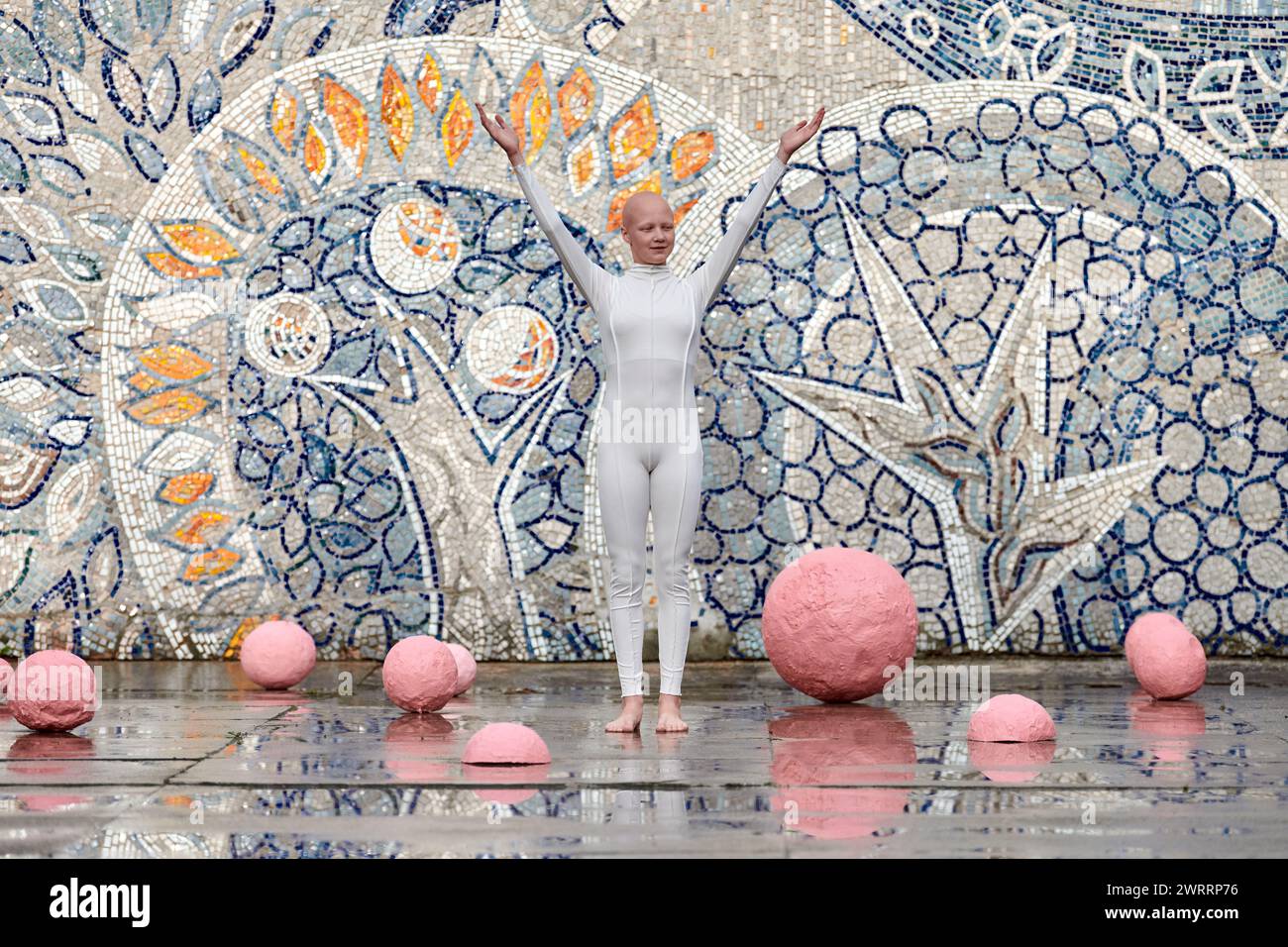 Young hairless girl ballerina with alopecia in white futuristic suit ...