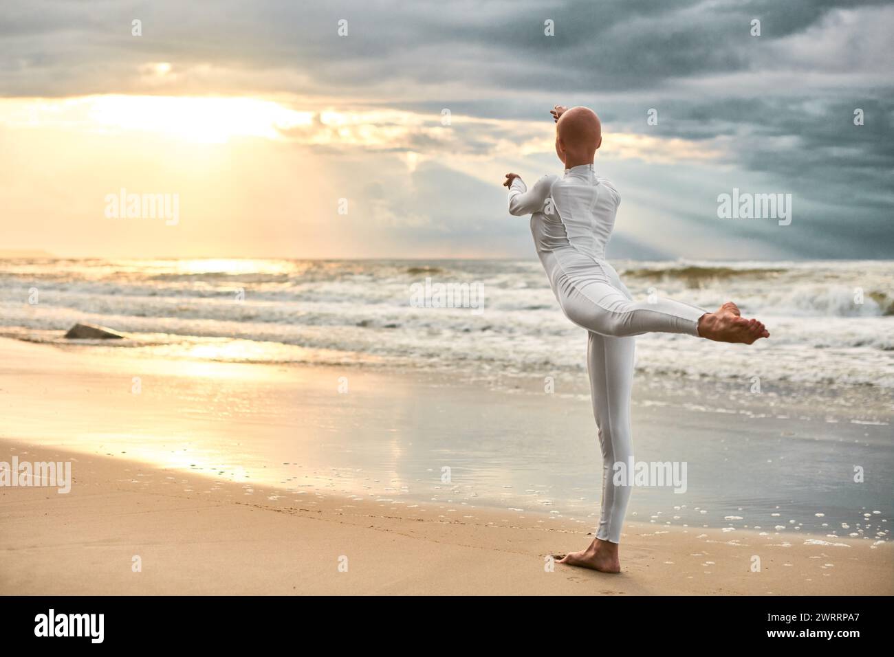 Young hairless ballerina with alopecia in white futuristic suit dancing ...