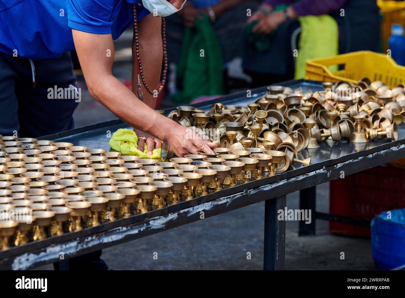 Nepali temple staff pour out candle oil after wick burns out for ...