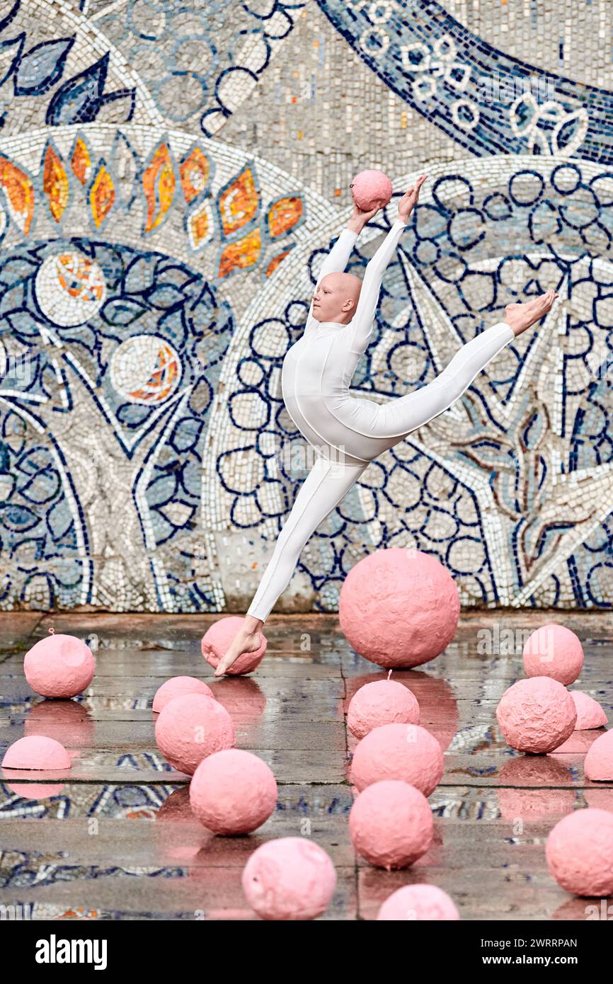 Young hairless girl ballerina with alopecia in white futuristic suit ...