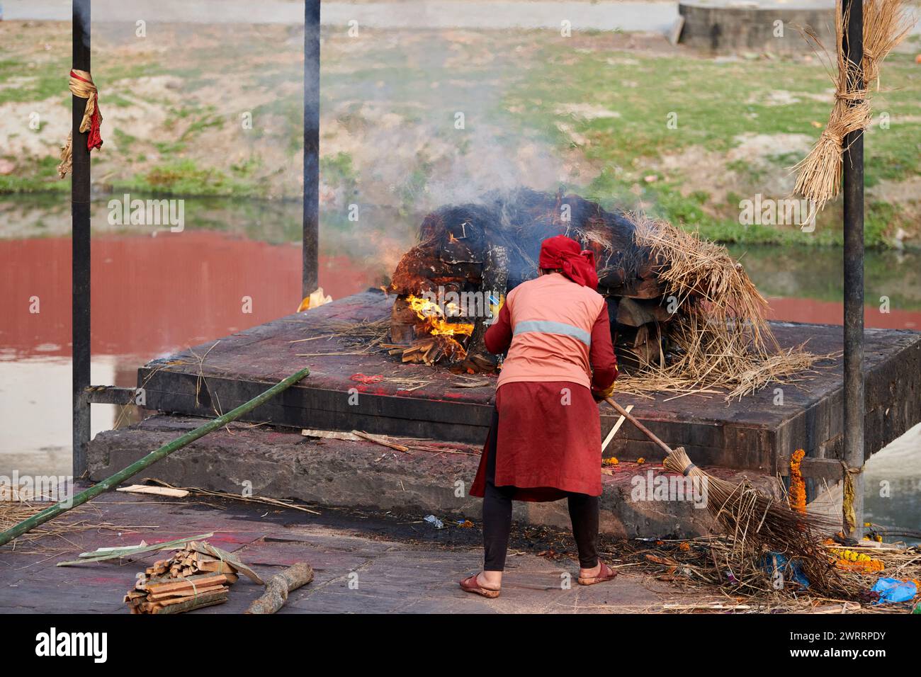 Staff employee of Pashupatinath Temple complex overseeing for funeral ...