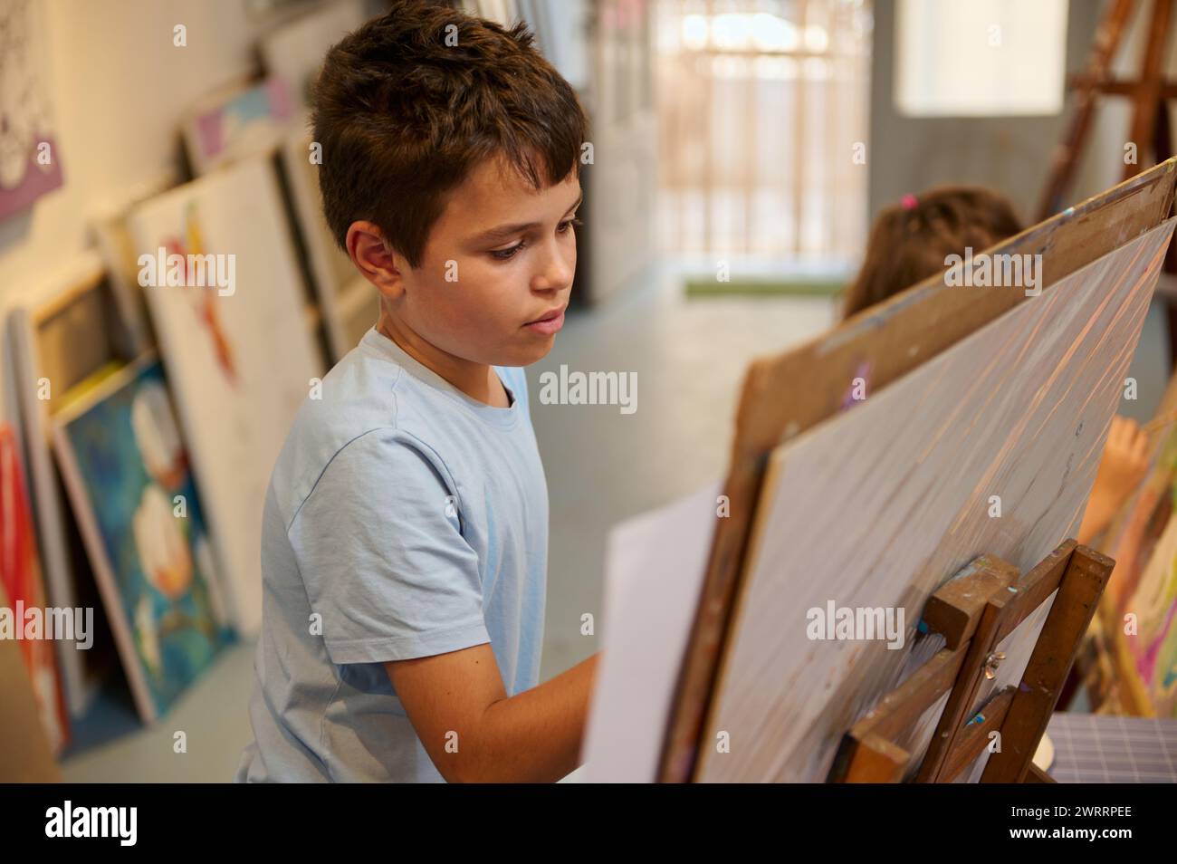 Closeup portrait of an inspired talented boy artist painter painting on ...