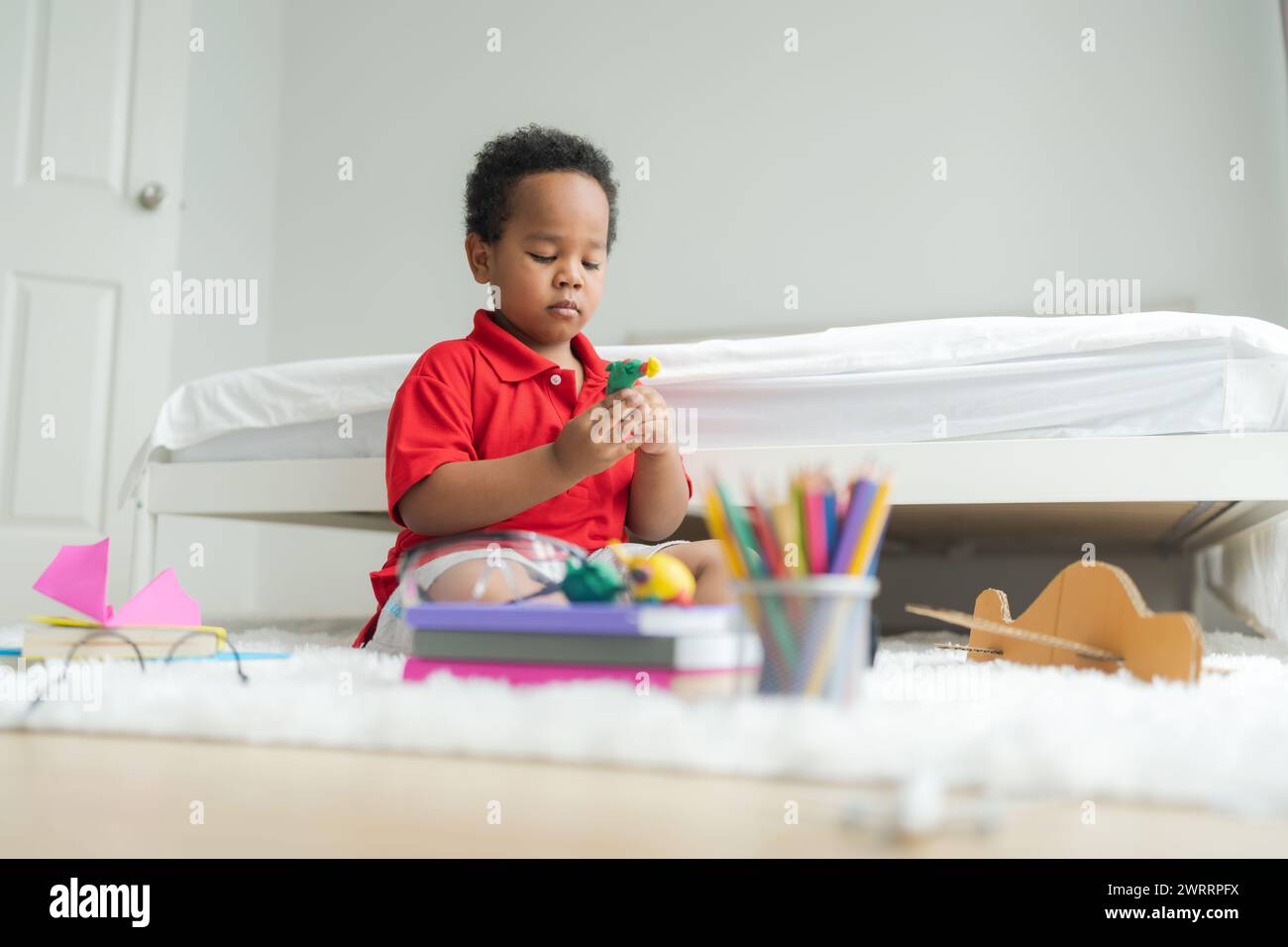 Cute little boy making things from plasticine on the ground Follow your ...