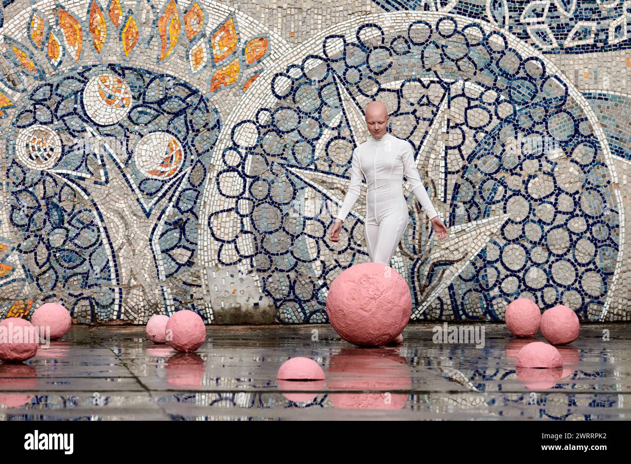 Young hairless girl ballerina with alopecia in white futuristic suit ...