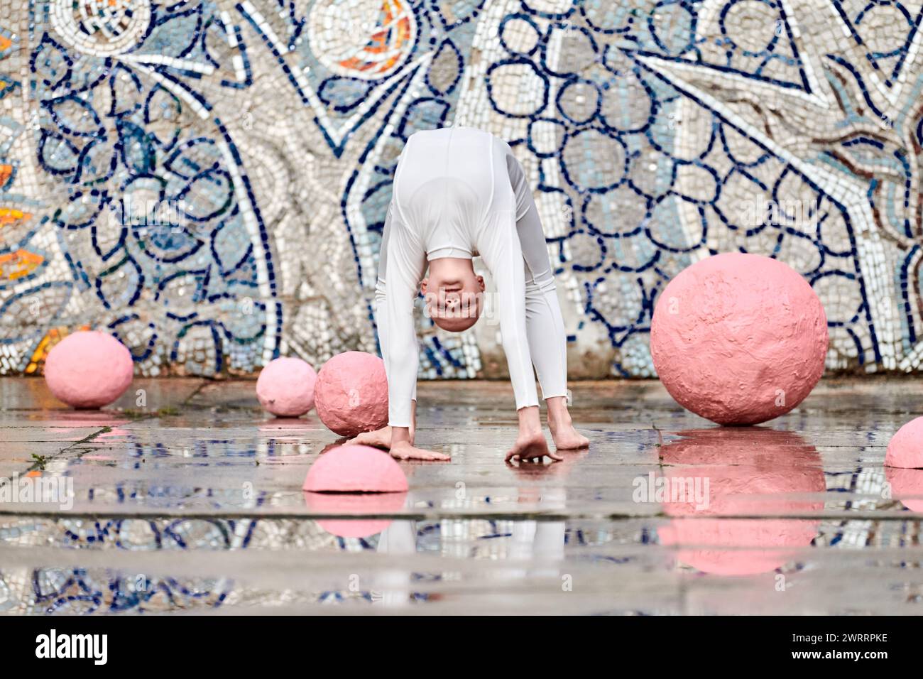 Outdoor dance of young ballerina girl with alopecia in white futuristic ...