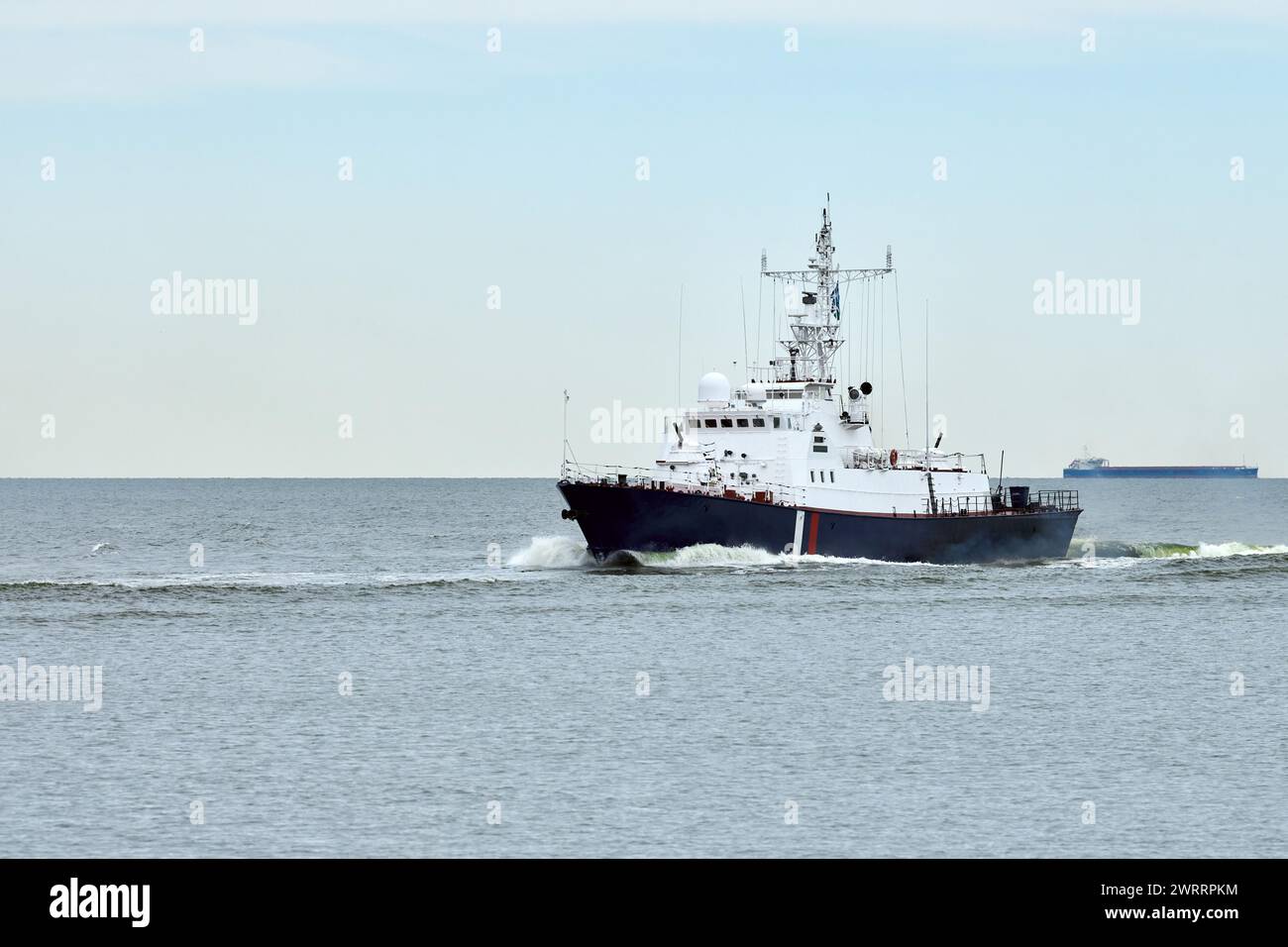 Coast guard ship sails along seaside for safeguarding coastal ...