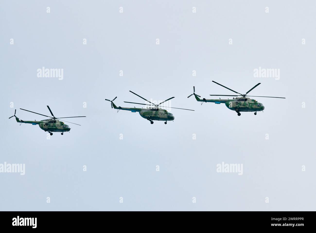 Three Russian military helicopters armed with missiles flies in blue ...