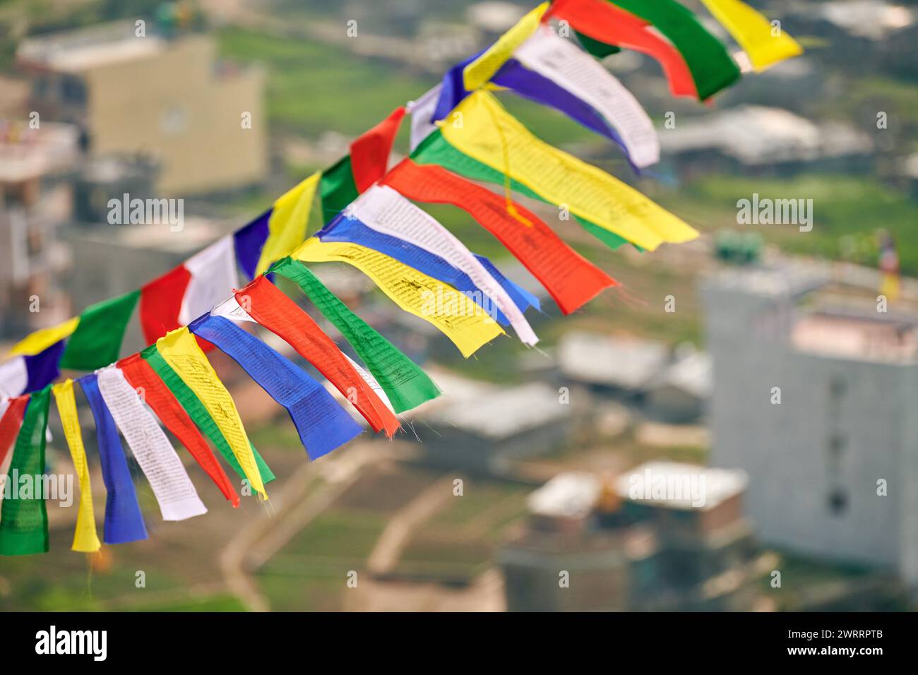 Colorful Tibetan prayer flags on blurred Kathmandu cityscape background ...