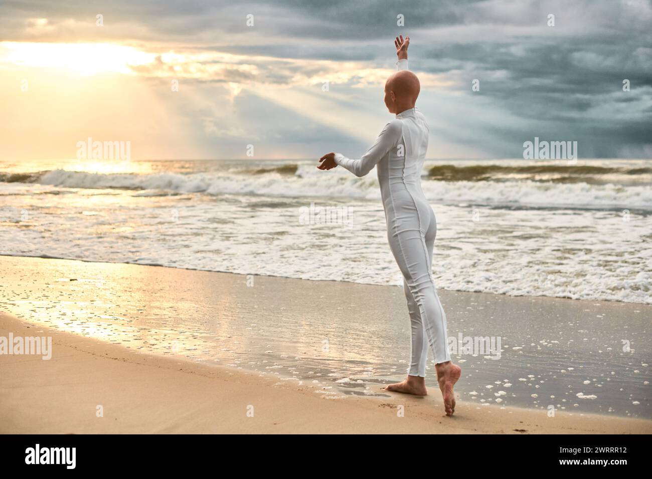 Young hairless ballerina with alopecia in white futuristic suit dancing ...