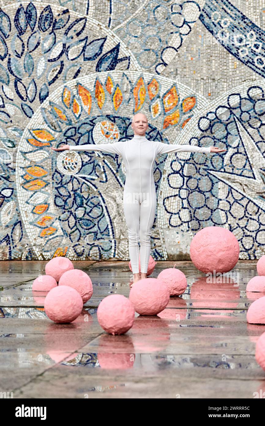 Young hairless girl ballerina with alopecia in white futuristic suit ...