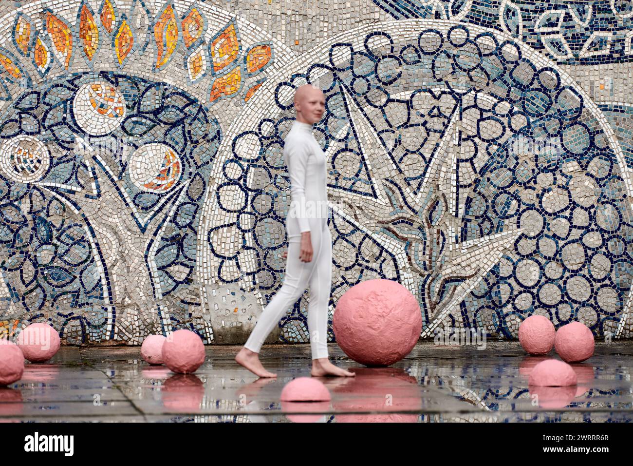 Young hairless girl ballerina with alopecia in white futuristic suit ...