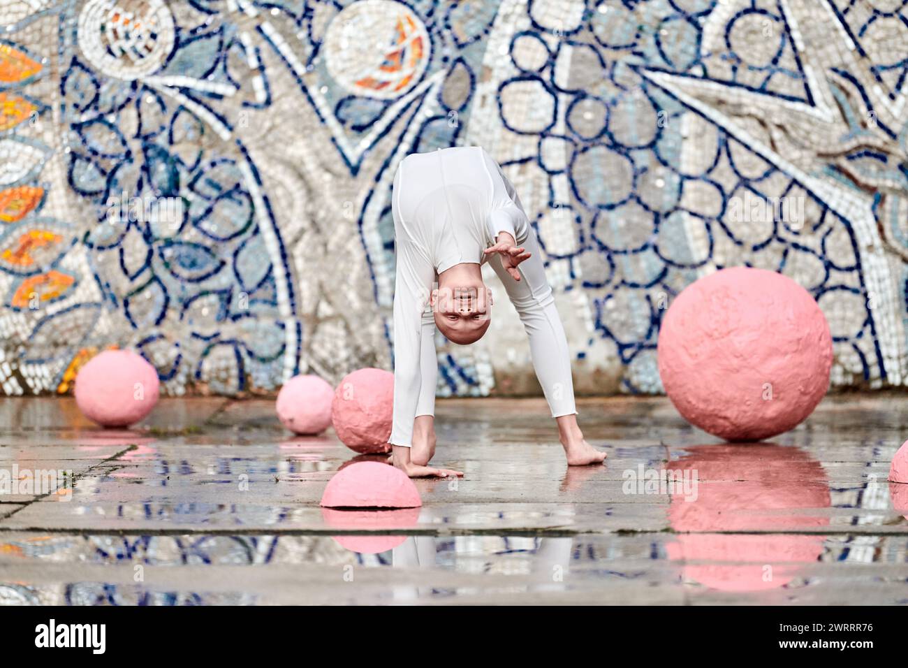 Outdoor dance of young ballerina girl with alopecia in white futuristic ...