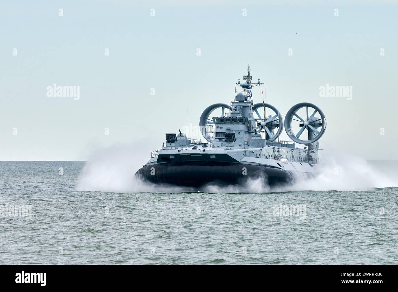 Hovercraft warship armed with armament sails into sea toward military target to attack and ...