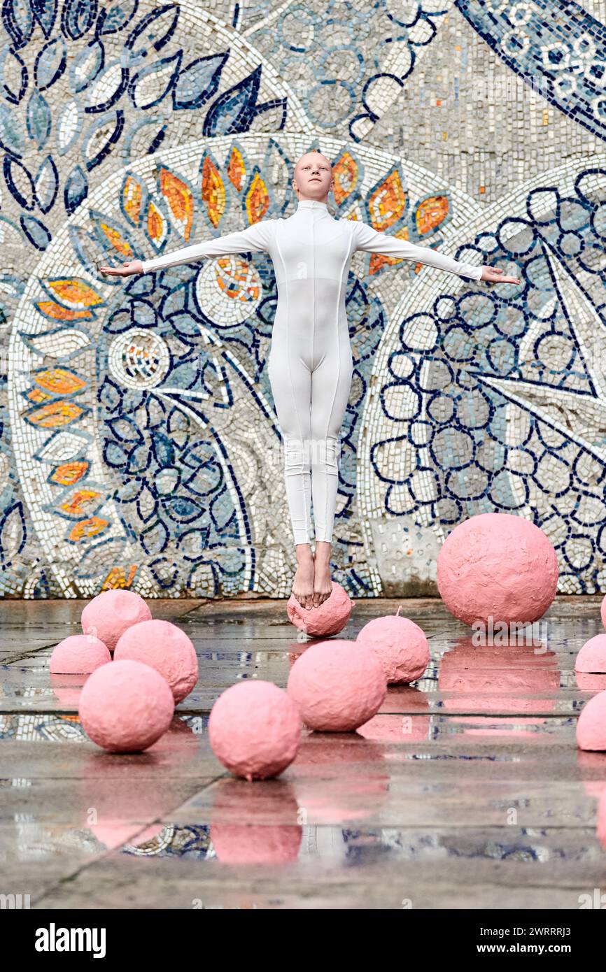 Young hairless girl ballerina with alopecia in white futuristic suit ...