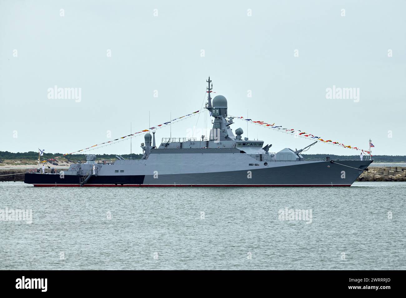 Russian naval ship with signal nautical flags anchored along shoreline ...