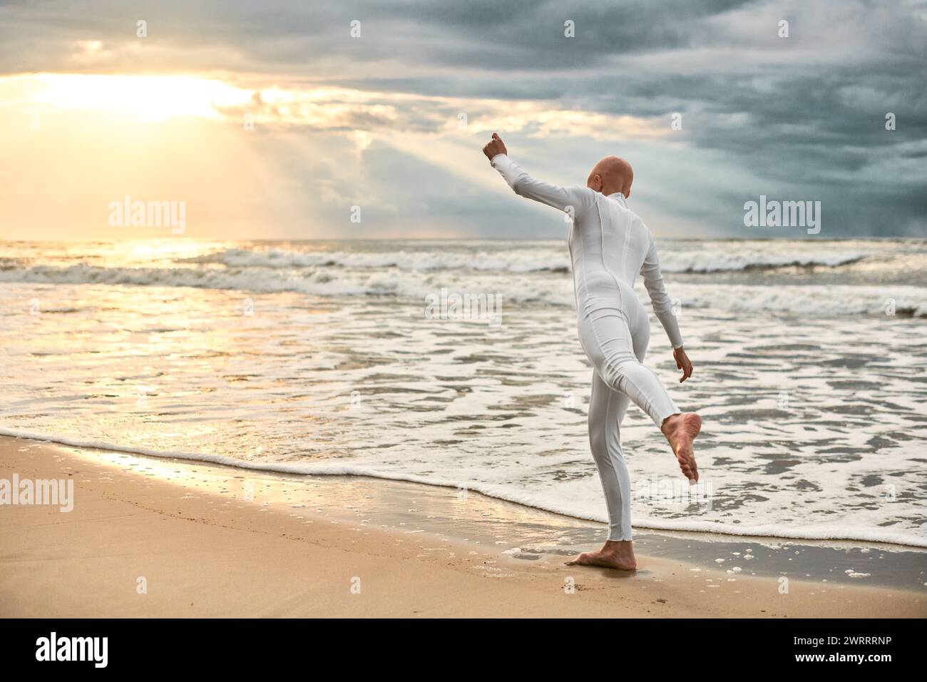 Young hairless ballerina with alopecia in white futuristic suit dancing ...