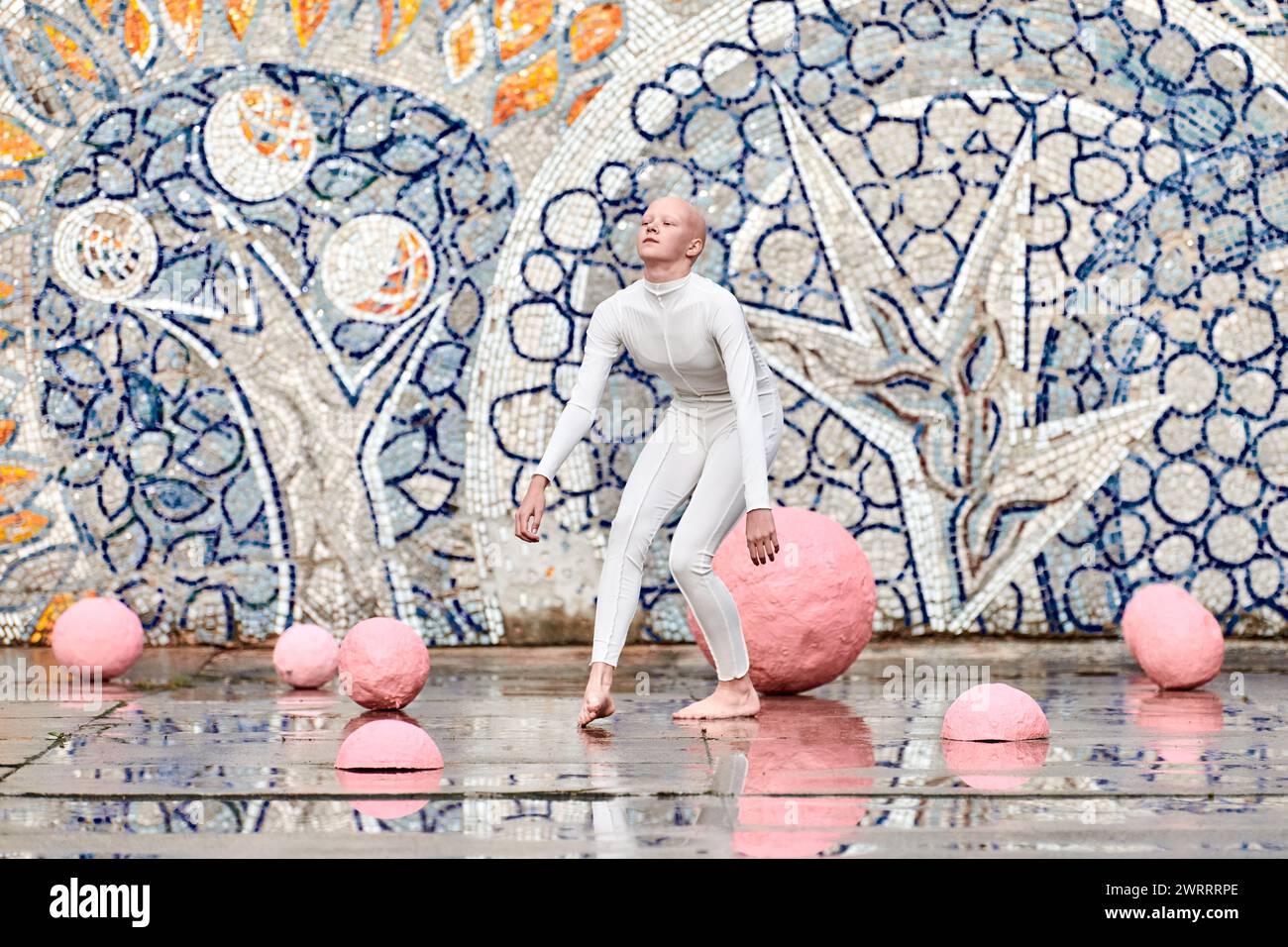 Young hairless girl ballerina with alopecia in white futuristic suit ...