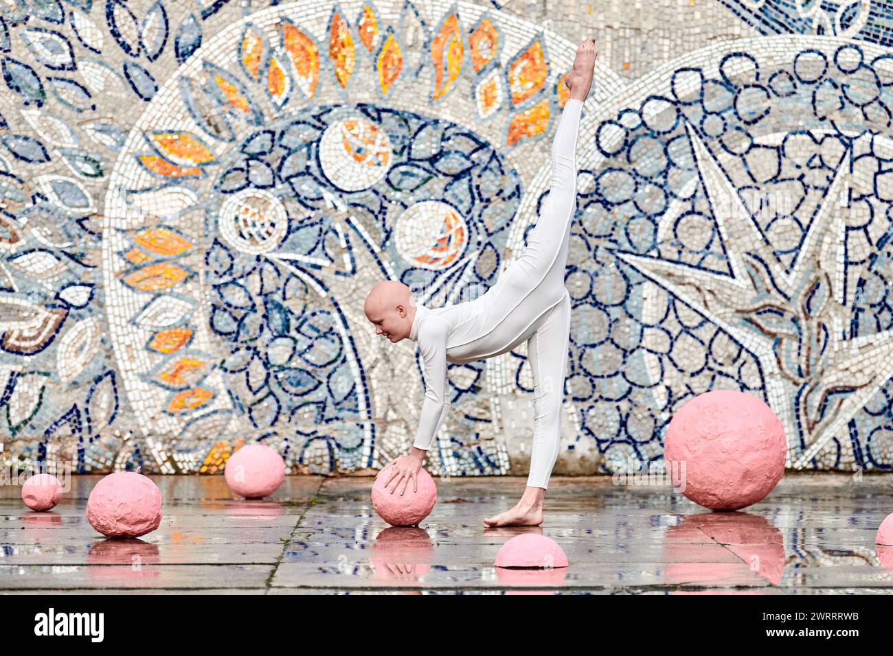 Outdoor dance of young ballerina girl with alopecia in white futuristic ...