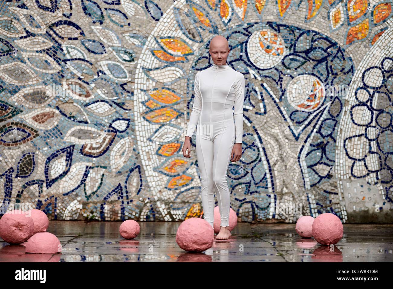 Young hairless girl ballerina with alopecia in white futuristic suit ...