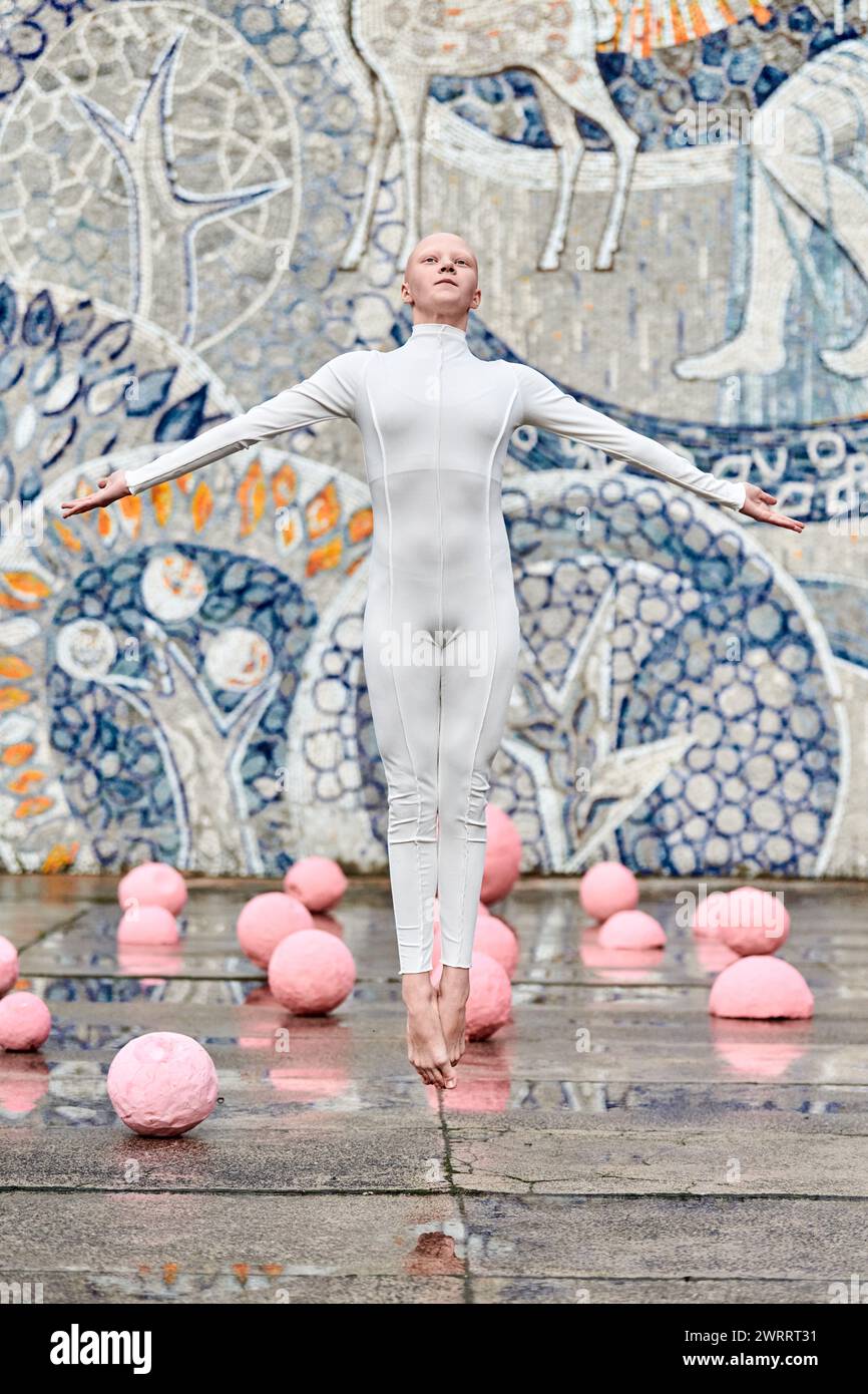 Young hairless girl ballerina with alopecia in white futuristic suit ...