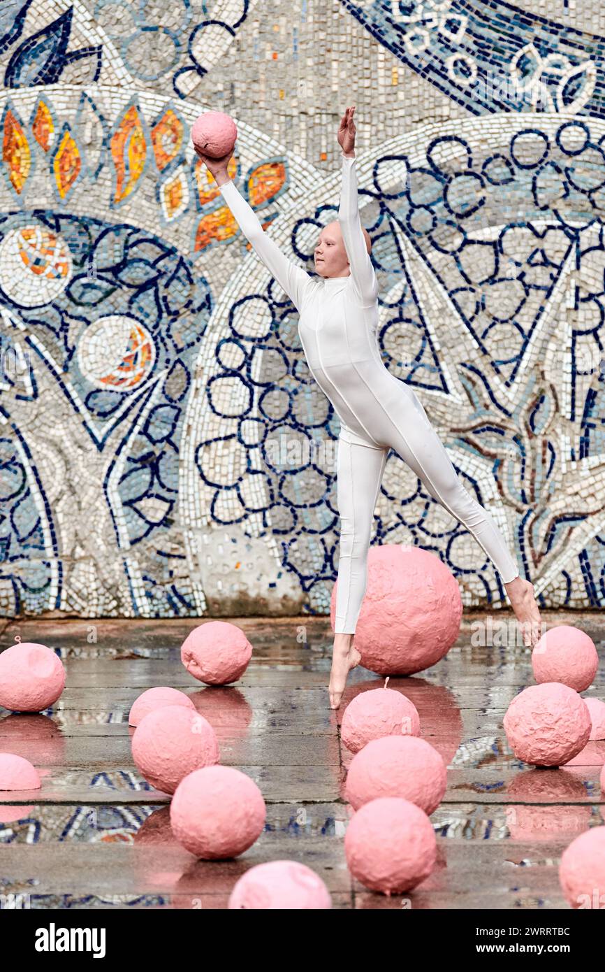 Young hairless girl ballerina with alopecia in white futuristic suit ...