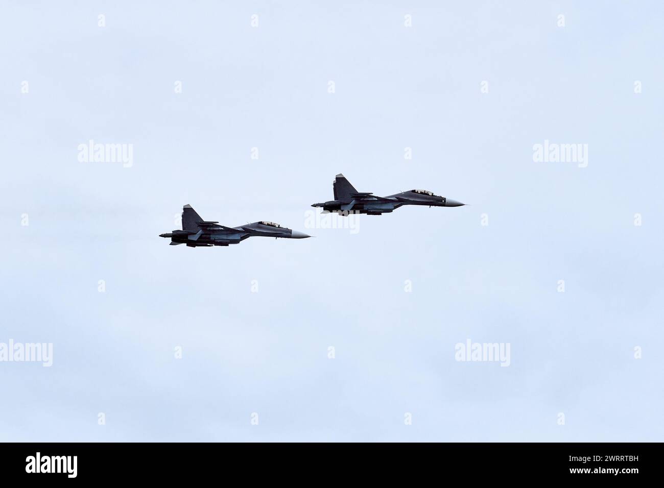 Two Russian military fighter planes armed with missiles flies in blue ...