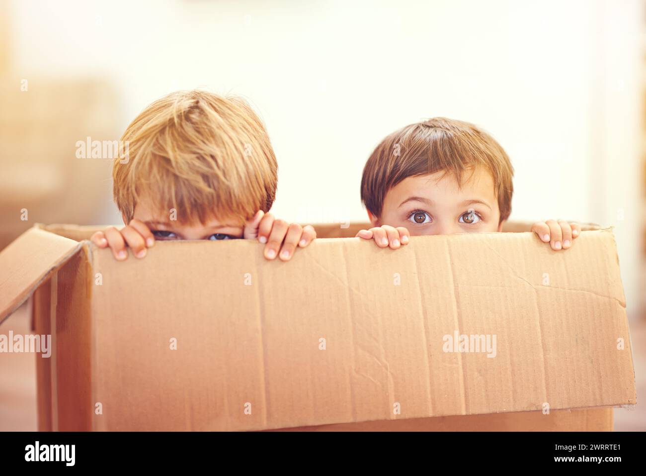 Children, box and eyes of siblings playing in a house with fun, bonding ...
