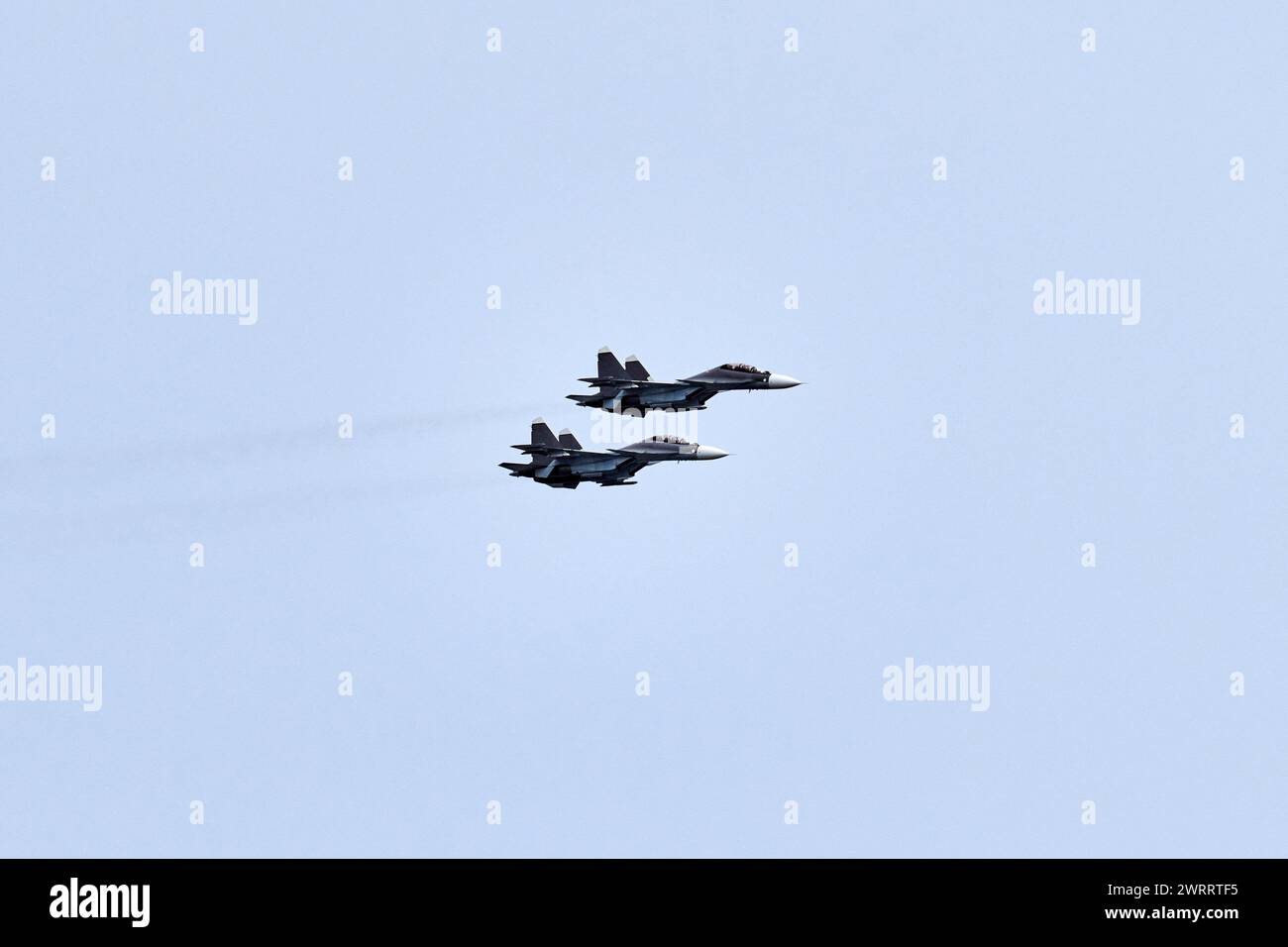 Two Russian military fighter planes armed with missiles flies in blue ...