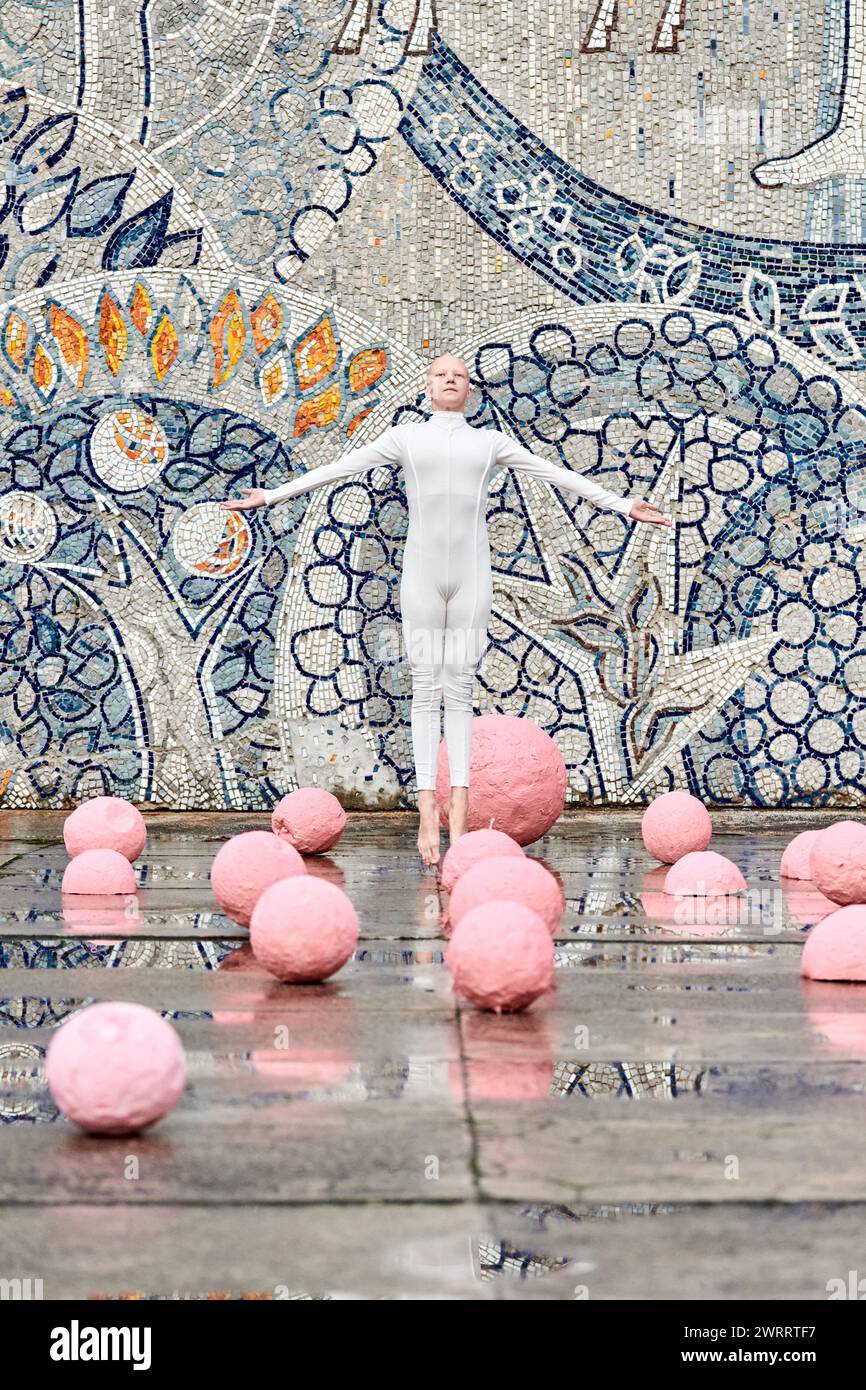 Young hairless girl ballerina with alopecia in white futuristic suit ...