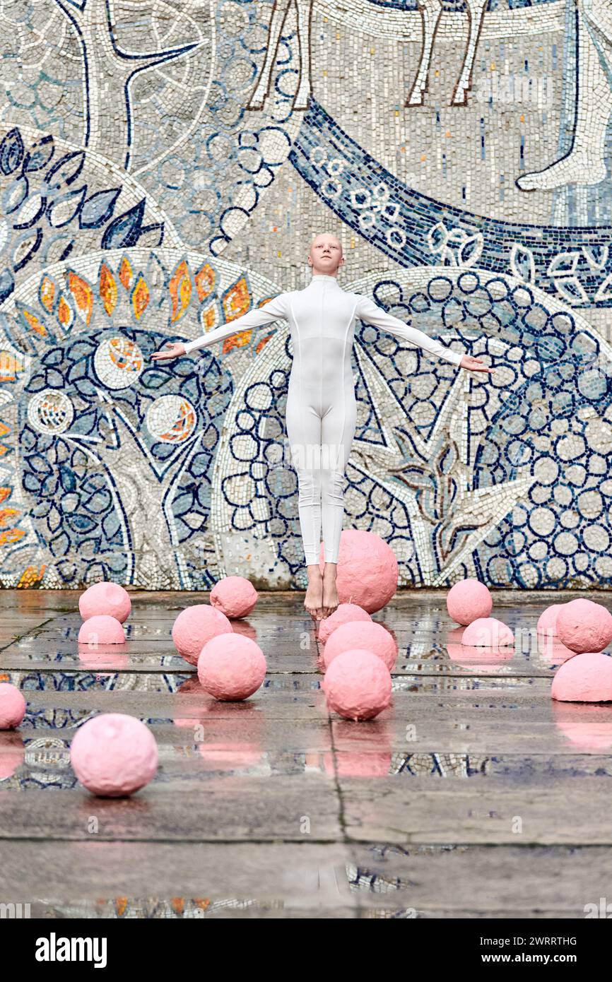 Young hairless girl ballerina with alopecia in white futuristic suit ...