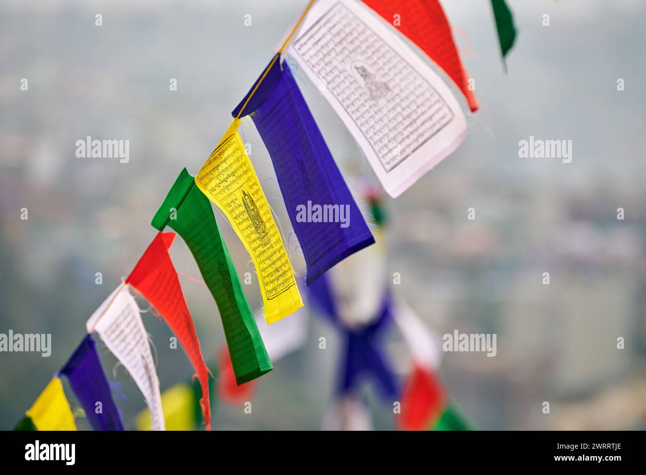 Colorful Tibetan prayer flags on blurred Kathmandu cityscape background ...