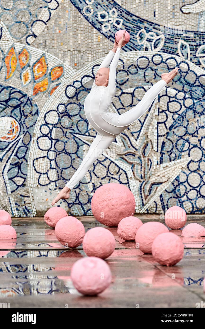 Young hairless girl ballerina with alopecia in white futuristic suit ...