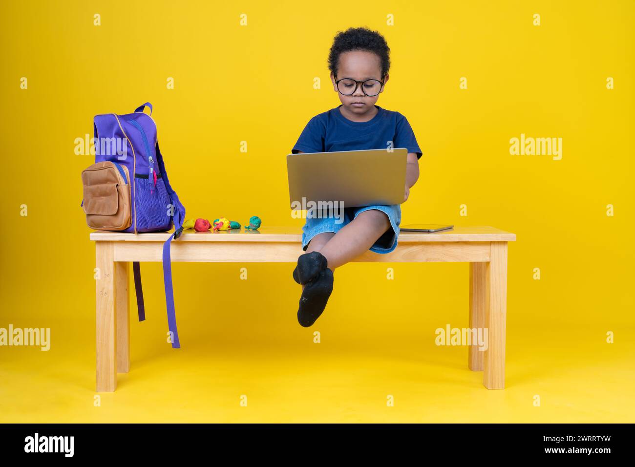 Cute little boy learning the internet or playing games with his laptop ...