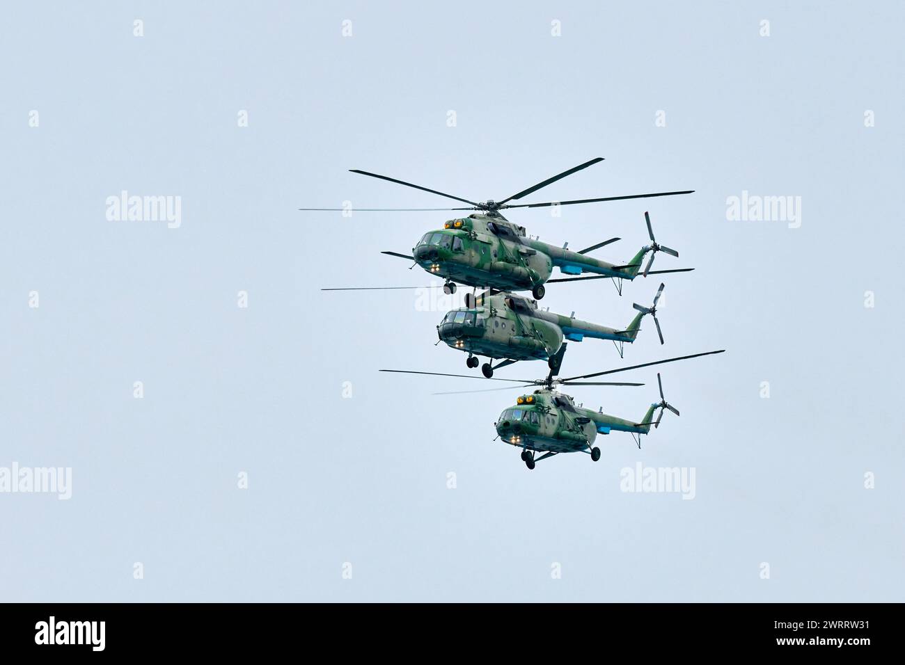 Three Russian military helicopters armed with missiles flies in blue ...