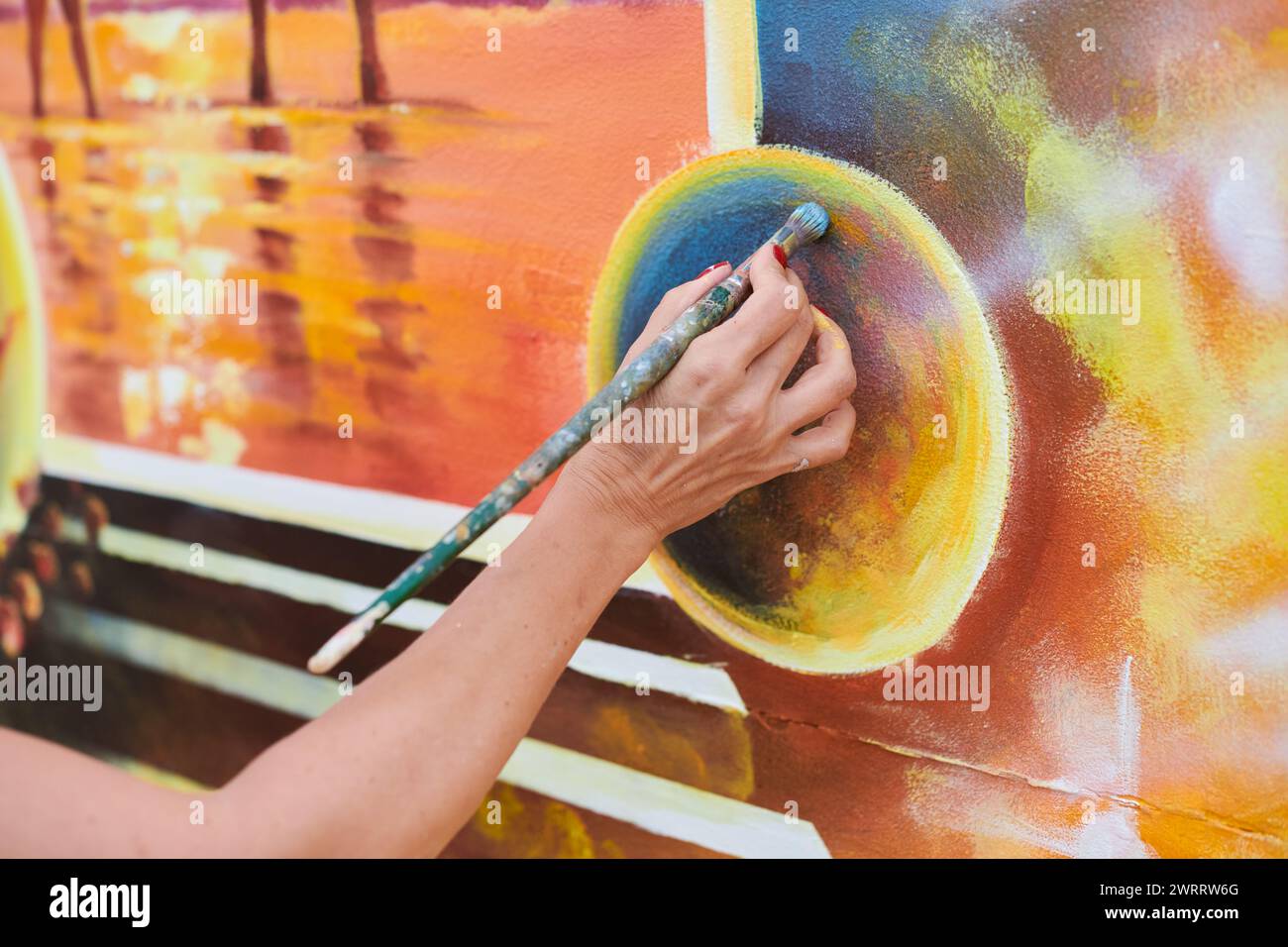 Female painter hand draws picture with paintbrush on canvas for ...