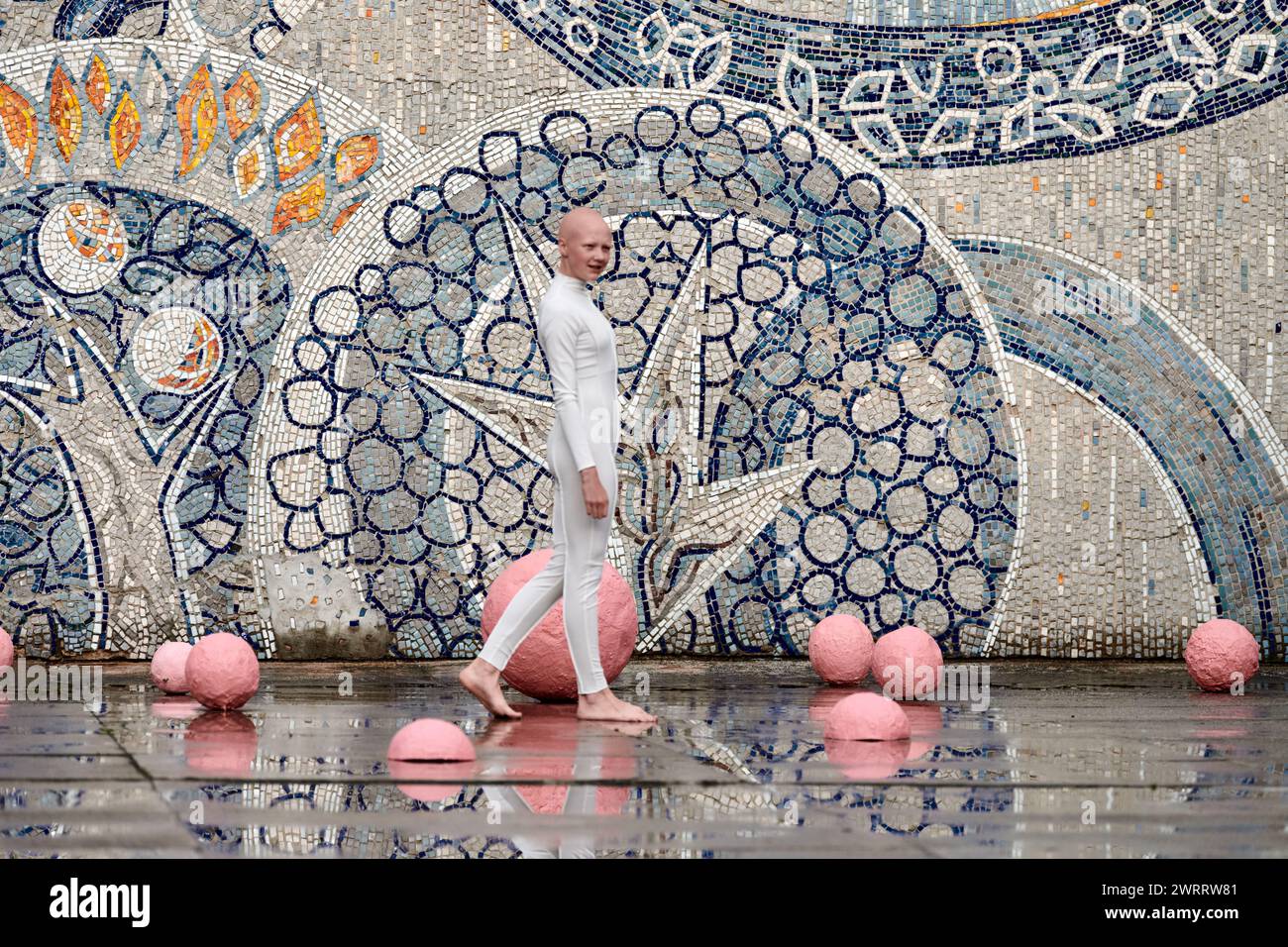 Young hairless girl ballerina with alopecia in white futuristic suit ...